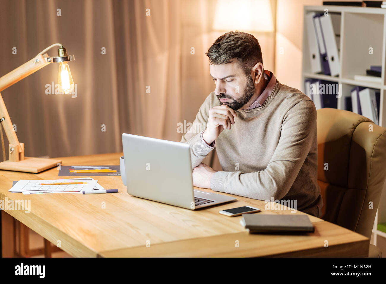 Concentrated male person looking at laptop Stock Photo - Alamy