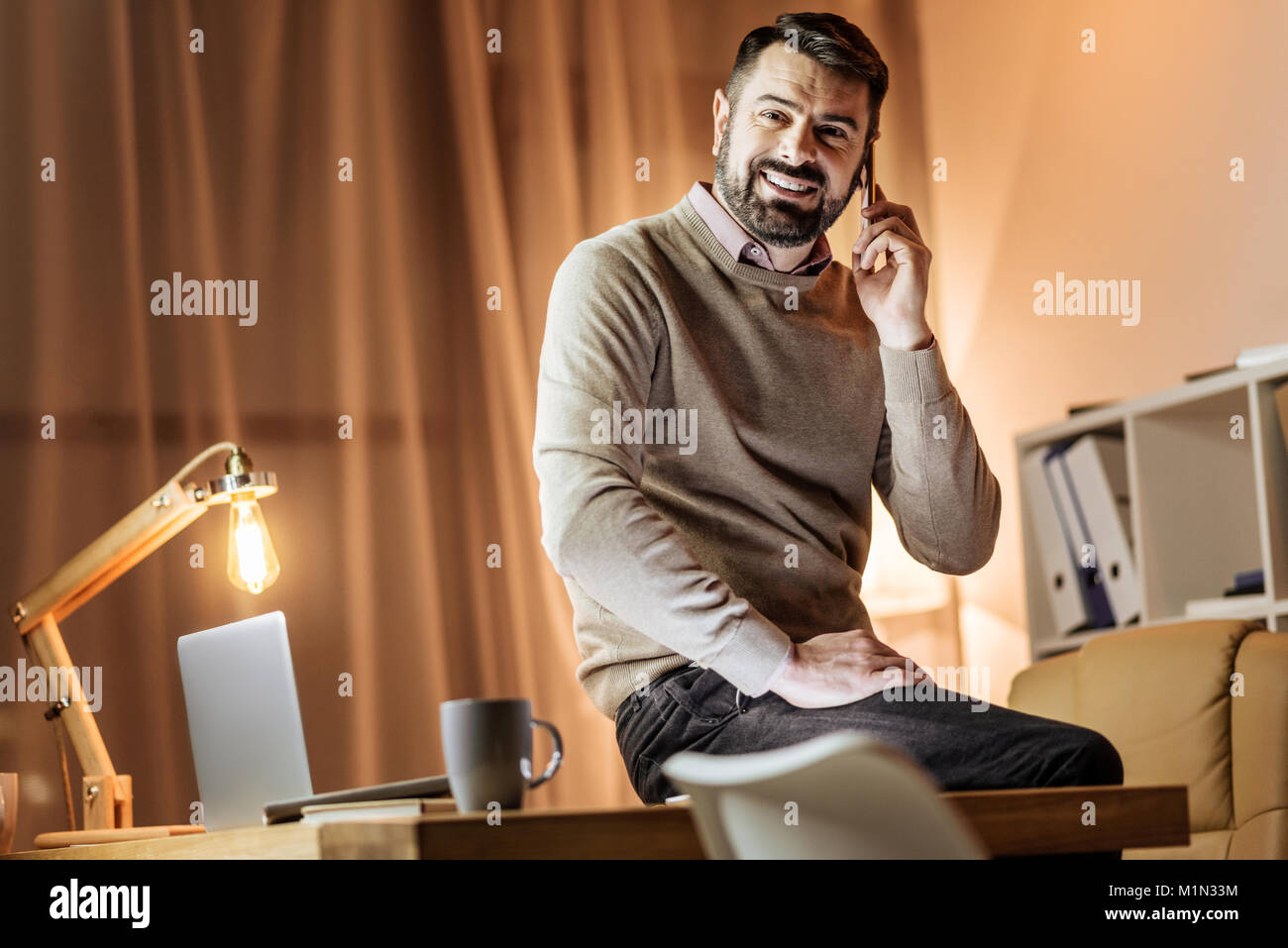 Handsome man sitting on the table Stock Photo - Alamy