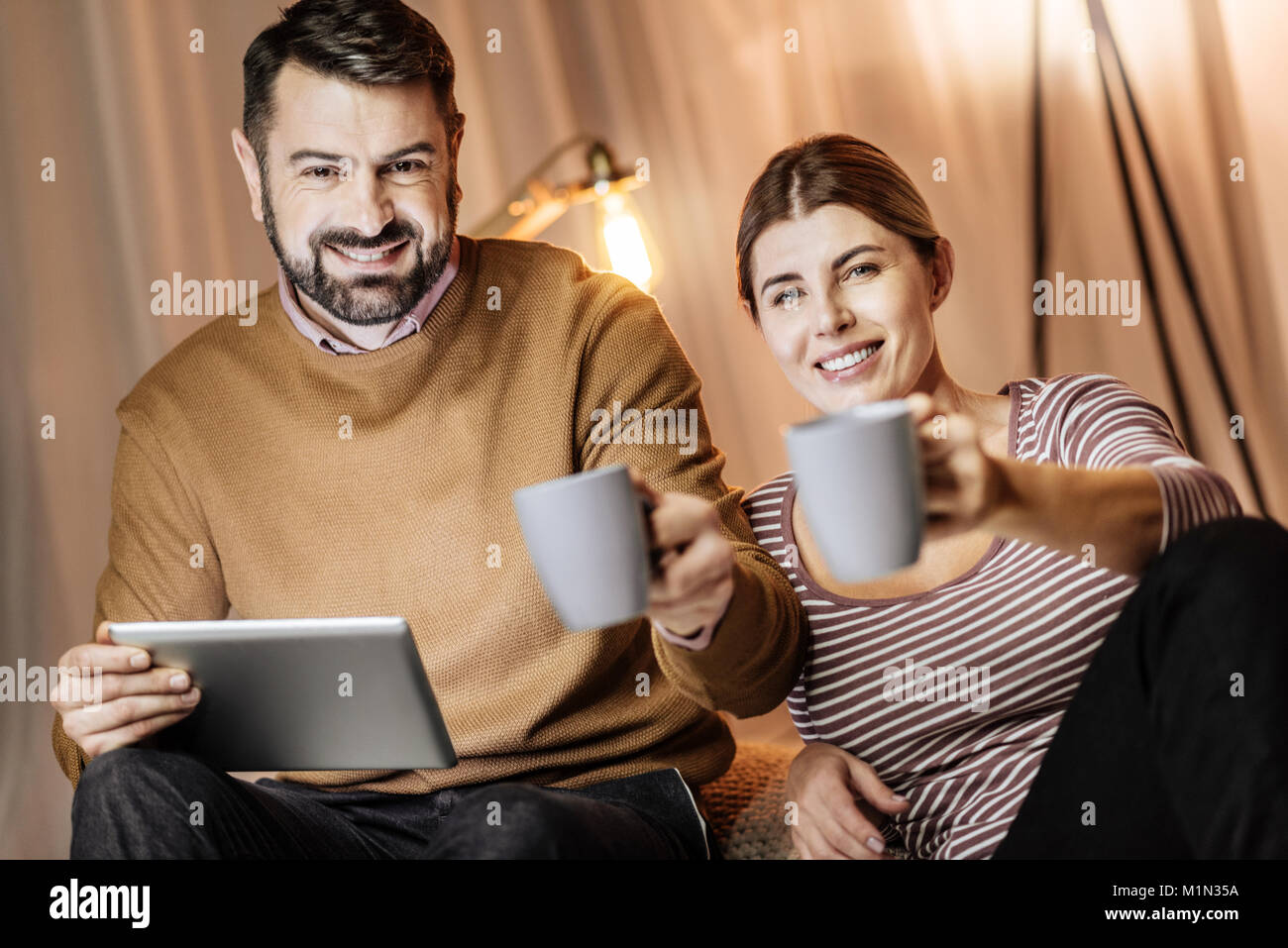 Pleased woman stretching arm with cup Stock Photo - Alamy