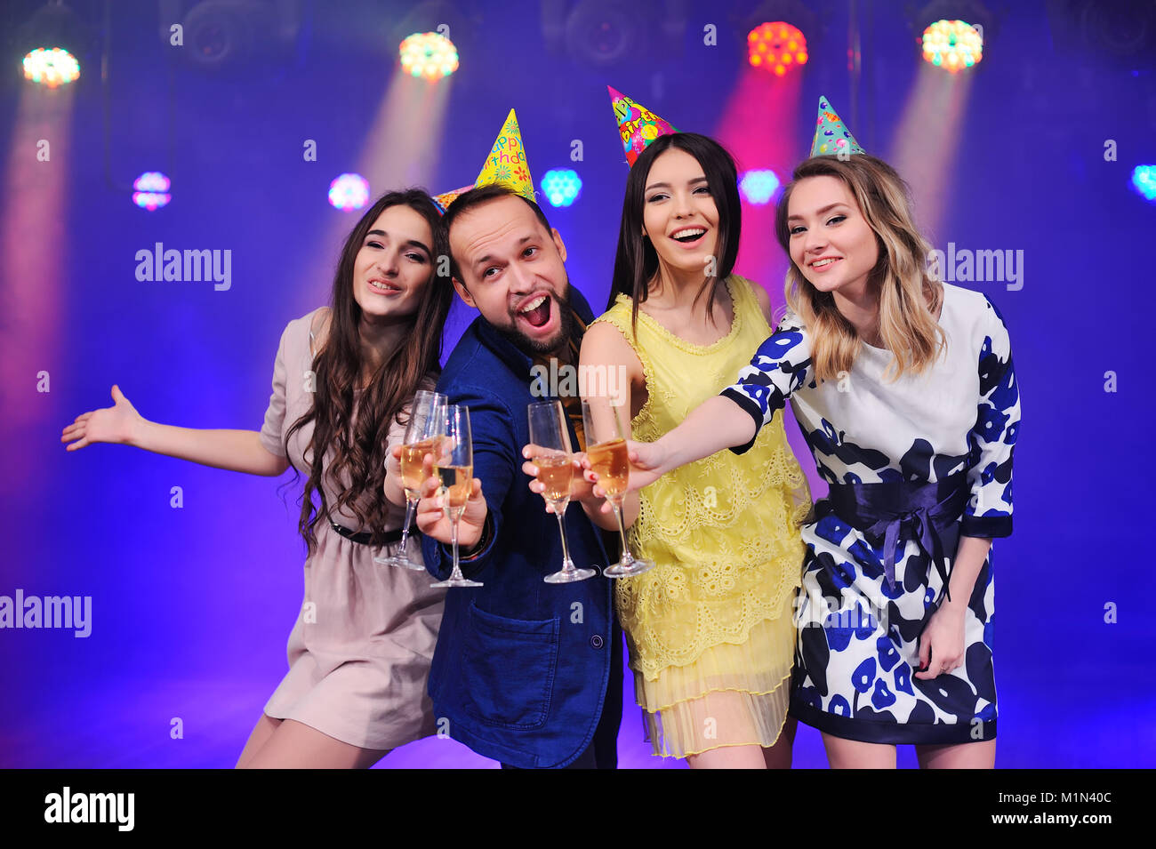 a guy and three girls rejoice and celebrate the party in the night club ...