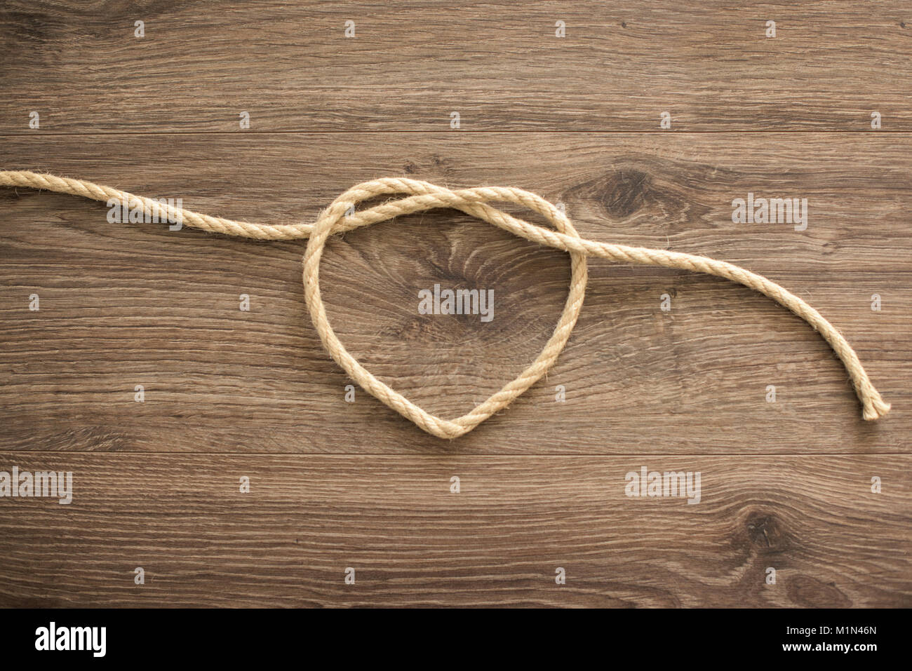 Heart shape made of rope on old wood Stock Photo - Alamy