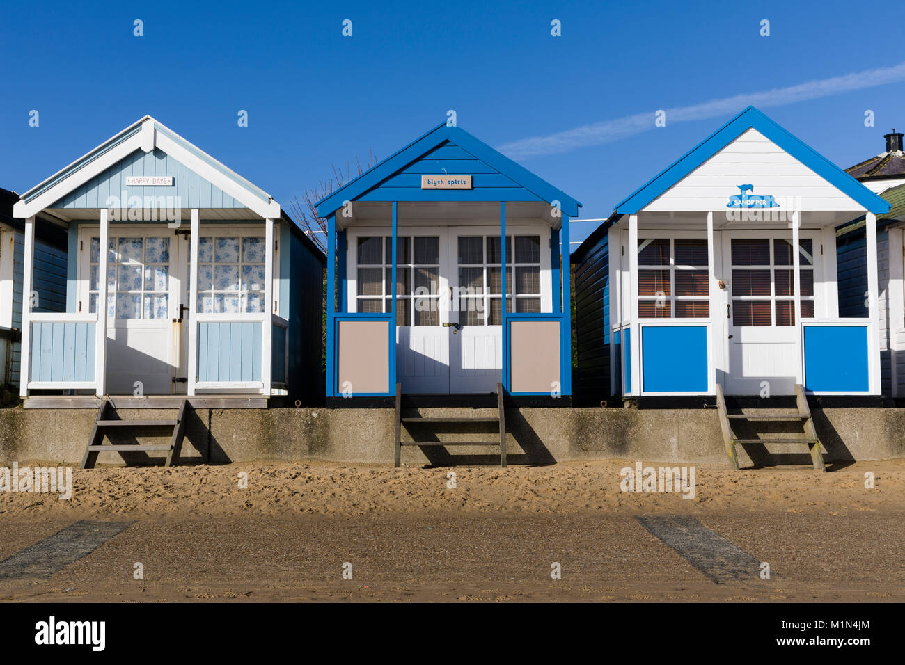 Traditional Seaside Beach Huts with a brilliant Blue Sky backdrop on ...