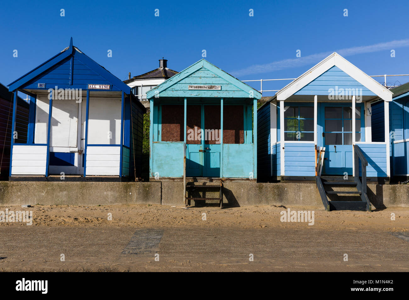 Traditional Seaside Beach Huts with a brilliant Blue Sky backdrop on ...