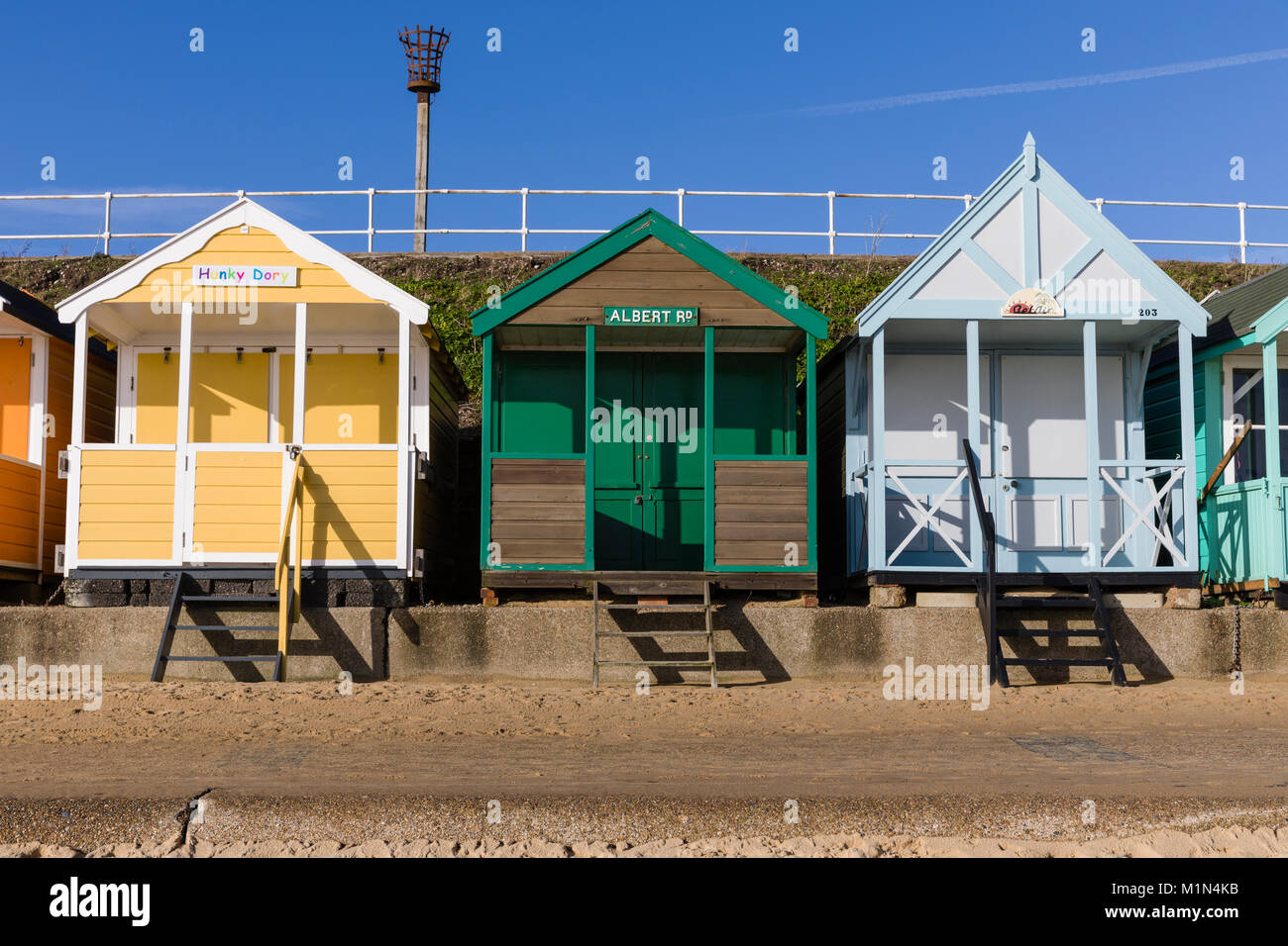 Traditional Seaside Beach Huts with a brilliant Blue Sky backdrop on ...