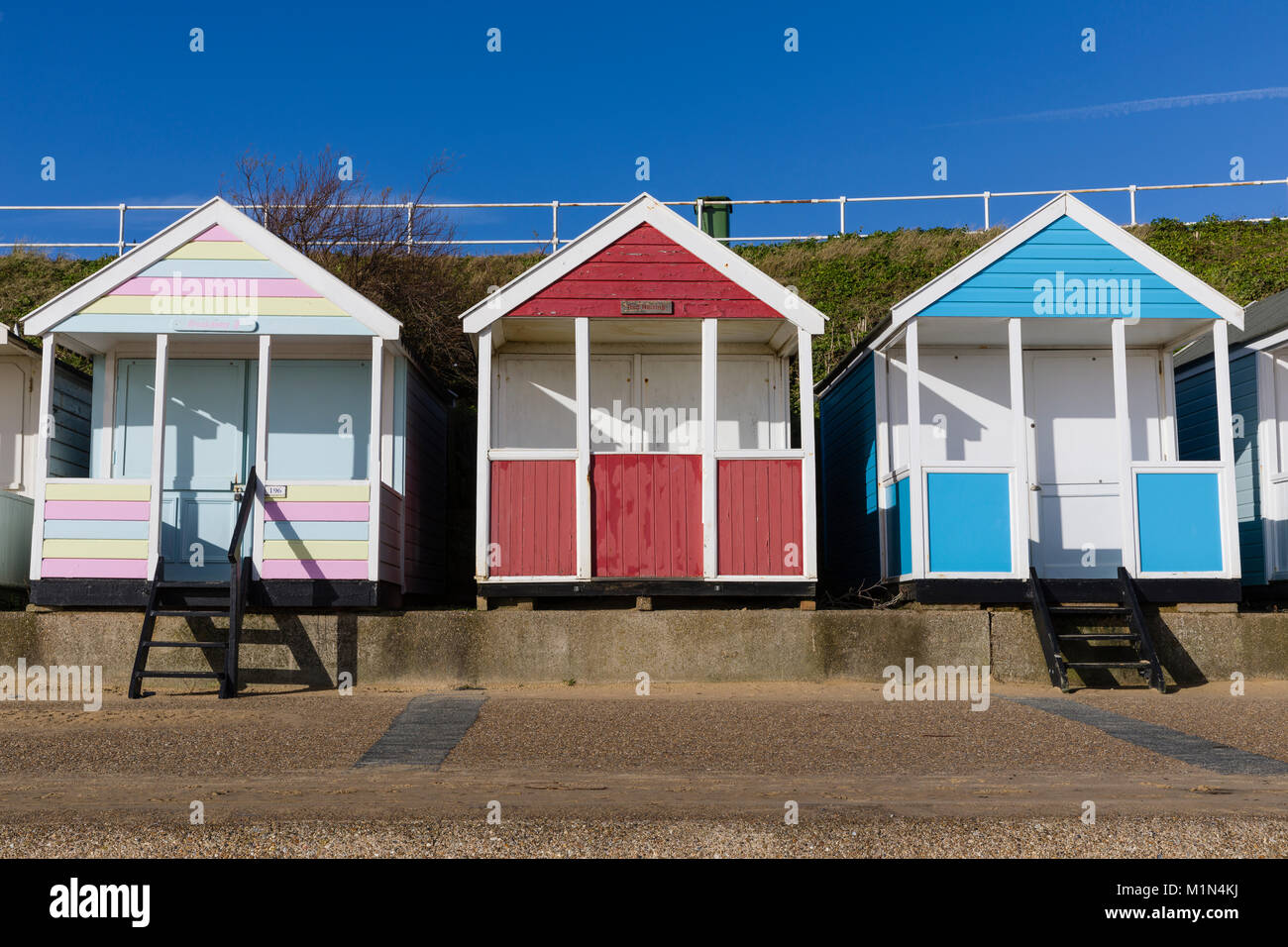 Traditional Seaside Beach Huts with a brilliant Blue Sky backdrop on ...
