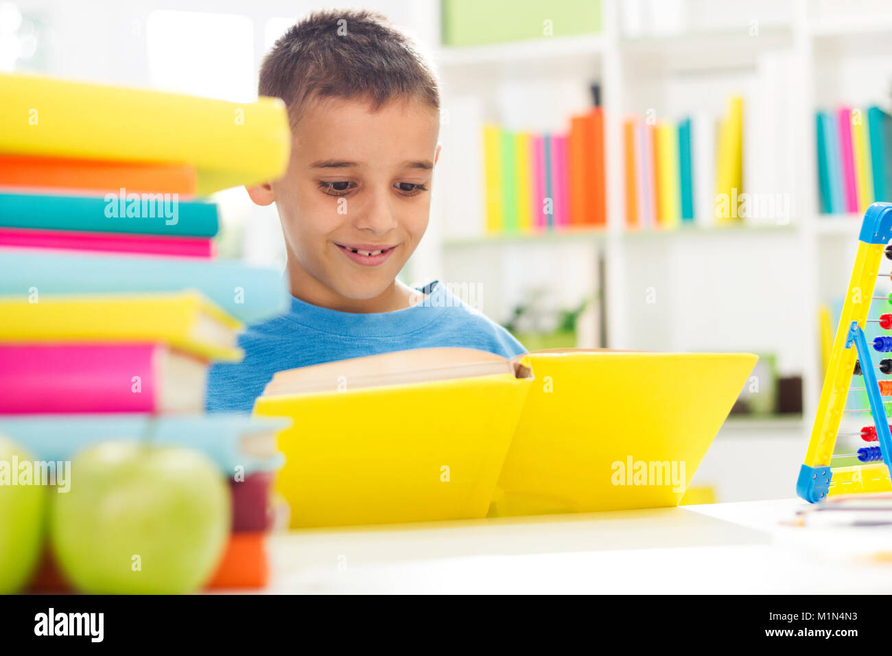 Happy smiling boy reading Stock Photo - Alamy