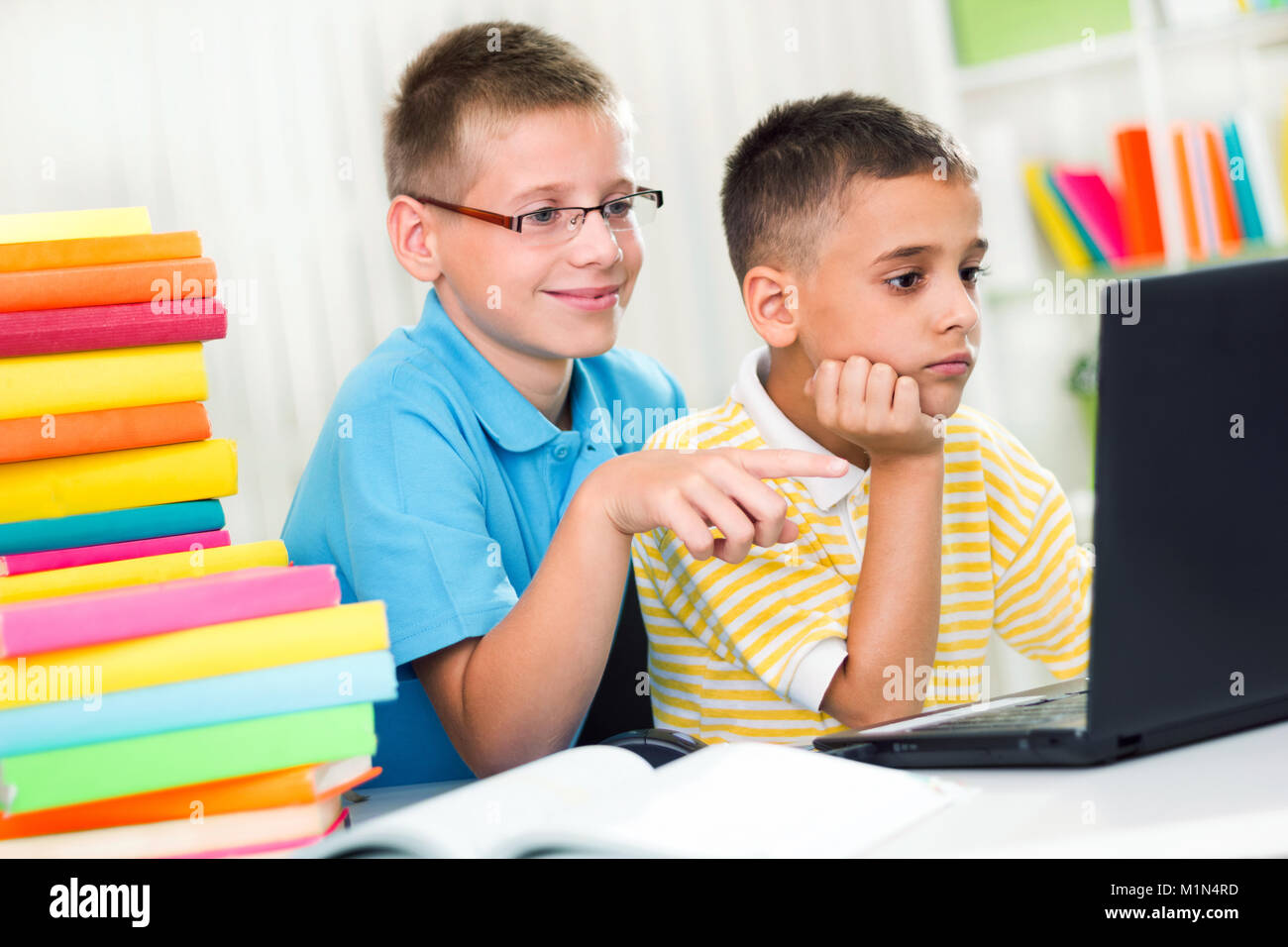 Two young boys having fun using laptop Stock Photo - Alamy
