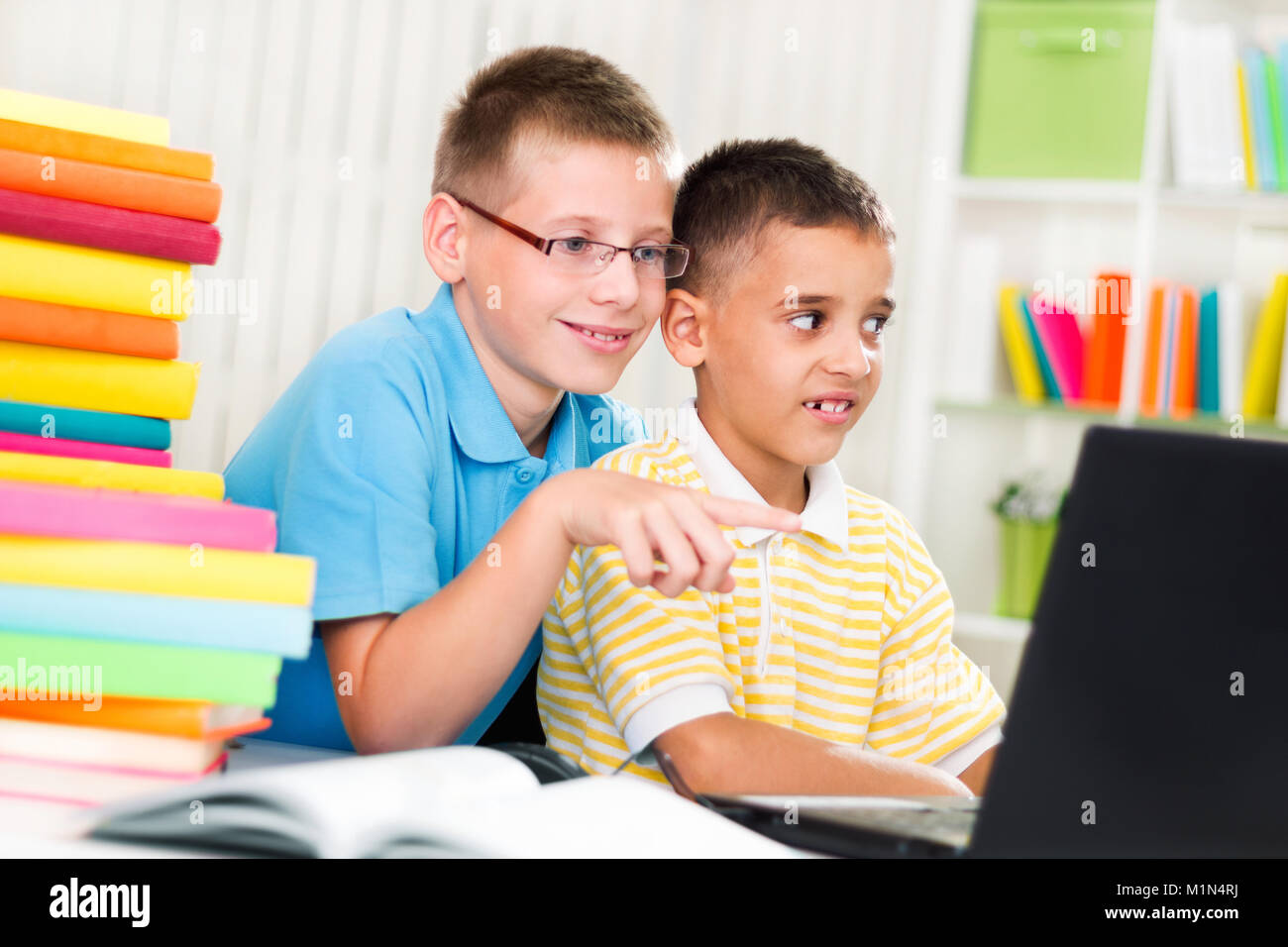 Two young boys having fun using laptop Stock Photo - Alamy