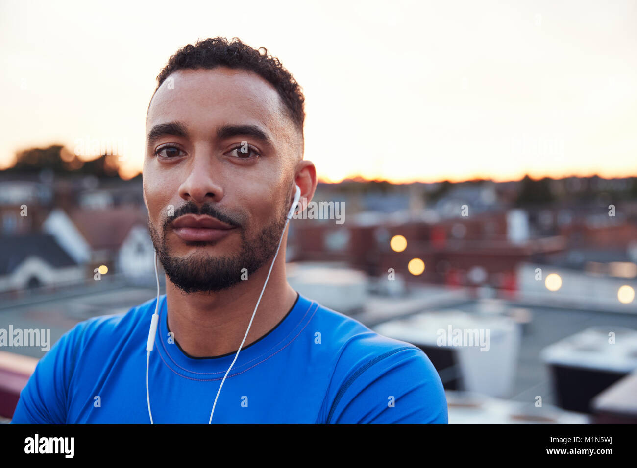Male runner in urban setting looking to camera, close up Stock Photo ...