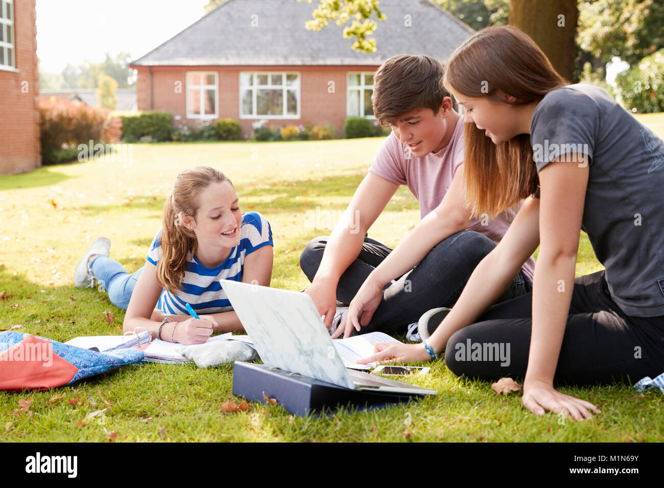 Teenage Students Sitting Outdoors And Working On Project Stock Photo ...