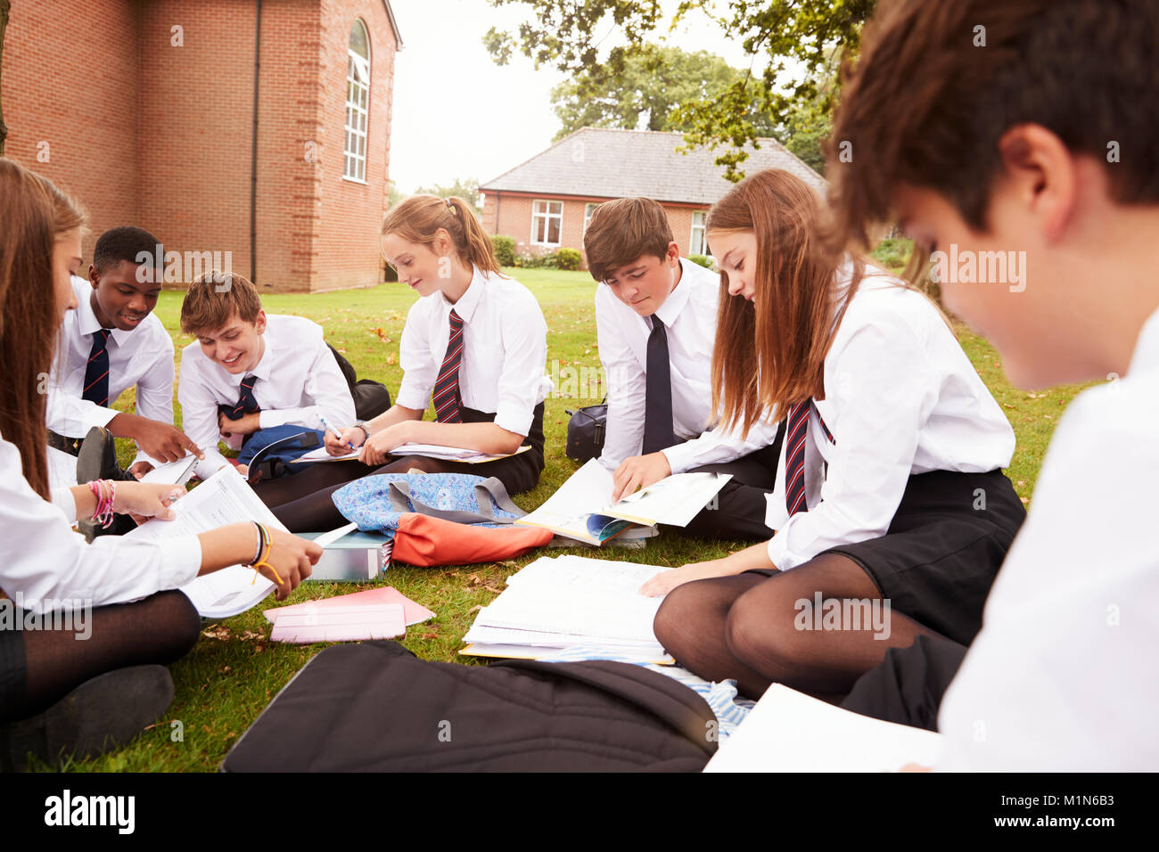 Teenage Students In Uniform Working On Project Outdoors Stock Photo - Alamy