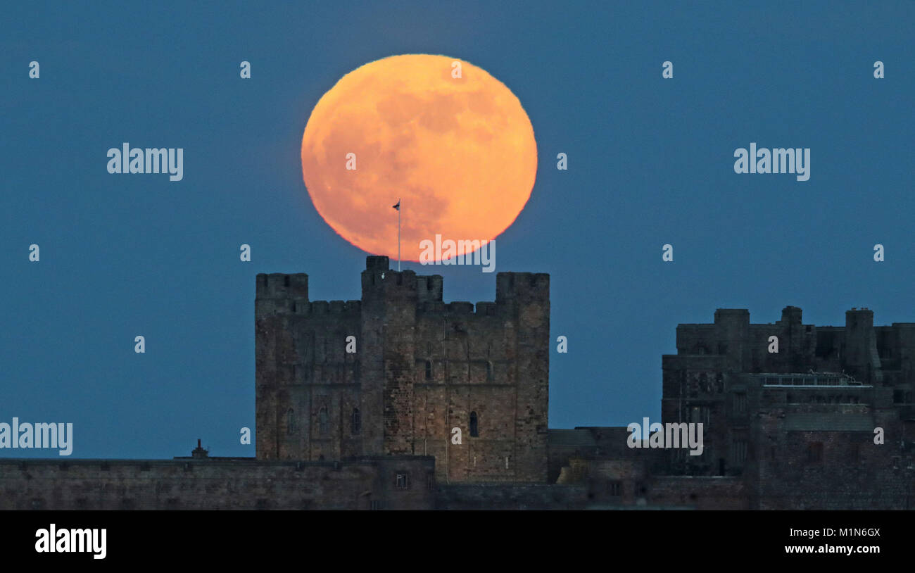 A blue moon rises over Bamburgh Castle in Northumberland Stock Photo ...