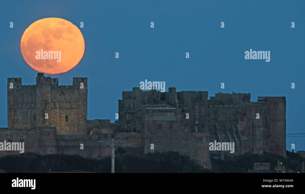 A blue moon rises over Bamburgh Castle in Northumberland Stock Photo ...