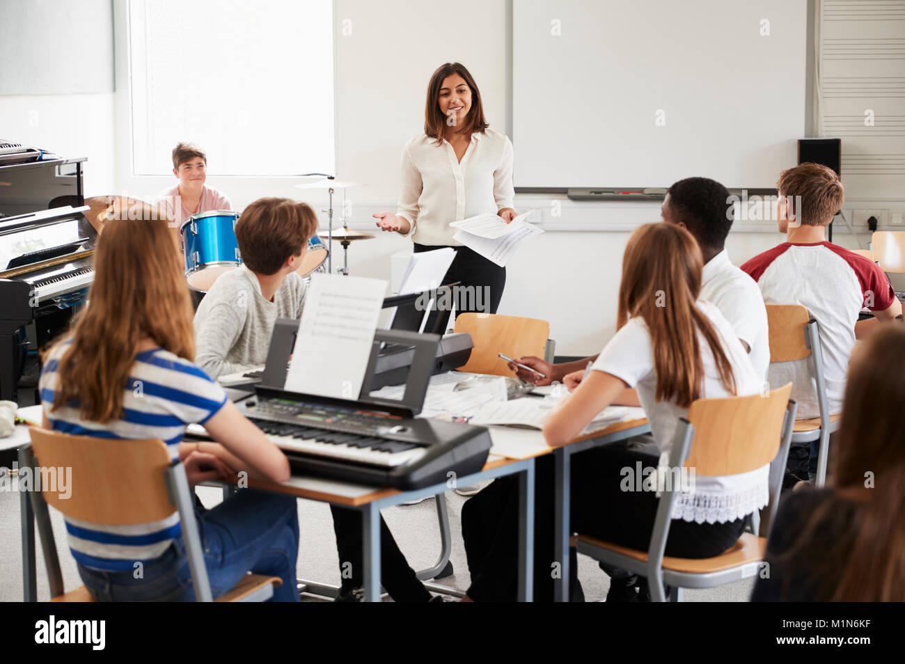 Teenage Students Studying In Music Class With Female Teacher Stock ...