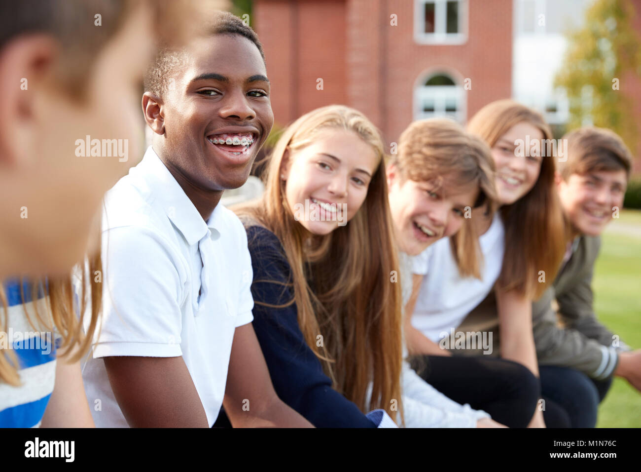 Group Of Teenage Students Sitting Outside School Buildings Stock Photo ...