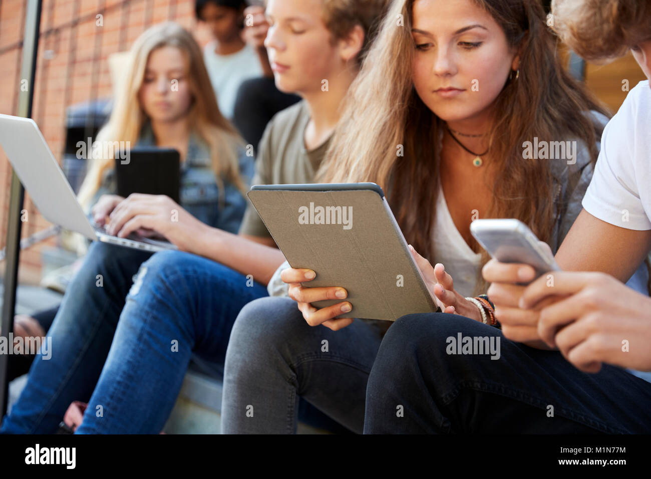 Teenage Students Using Digital Devices On College Campus Stock Photo ...