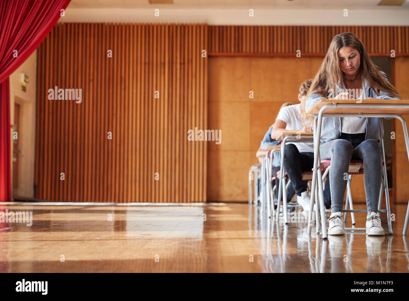 Group Of Teenage Students Sitting Examination In School Hall Stock ...