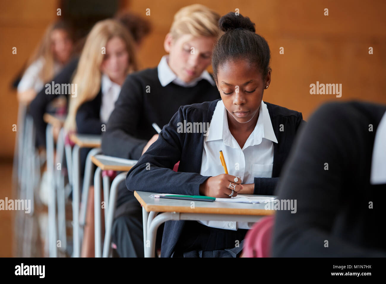 Teenage Students In Uniform Sitting Examination In School Hall Stock ...