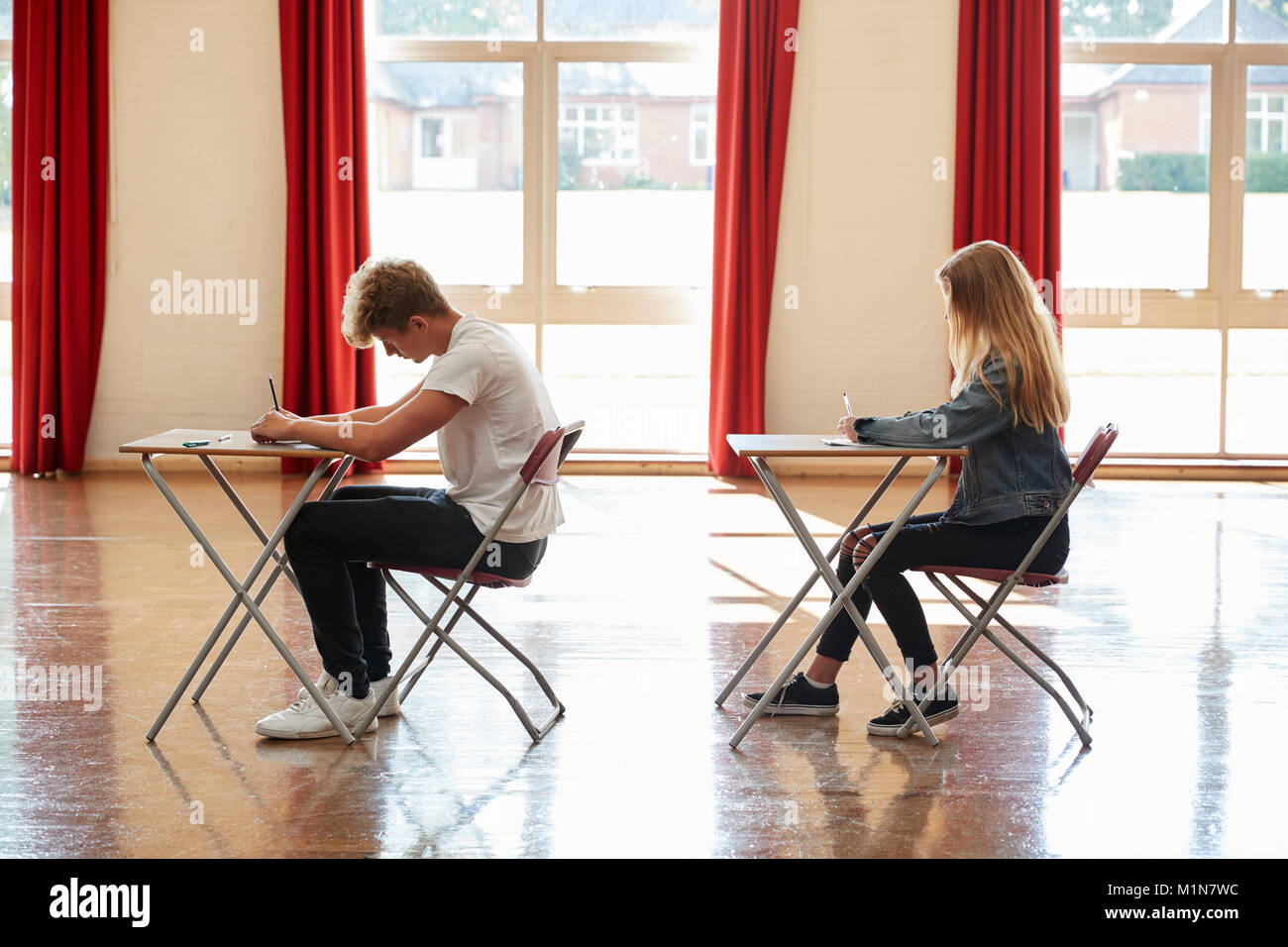 Group Of Teenage Students Sitting Examination In School Hall Stock ...