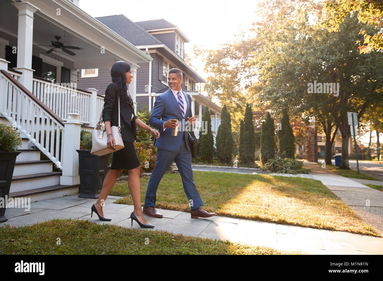 Business Couple Leaving Suburban House For Commute To Work Stock Photo ...