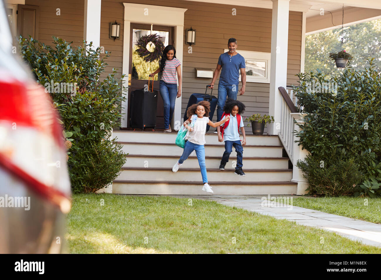 Family With Luggage Leaving House For Vacation Stock Photo - Alamy