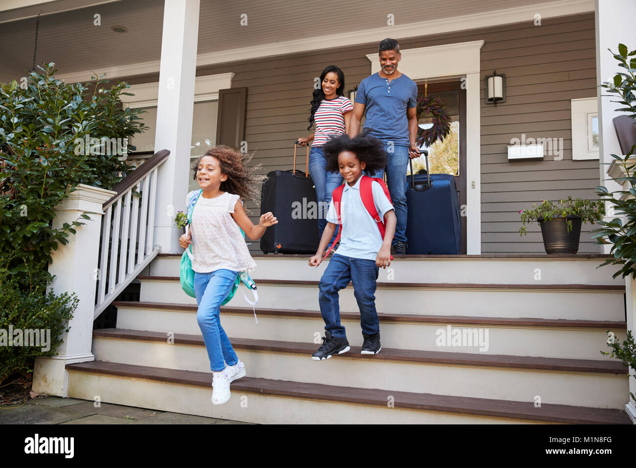 Family With Luggage Leaving House For Vacation Stock Photo - Alamy