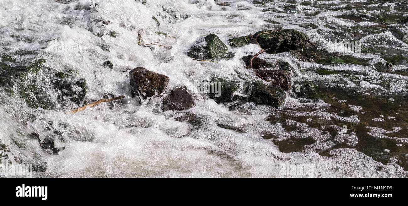 tree branch on rocks in stream, small waterfall. background, nature ...