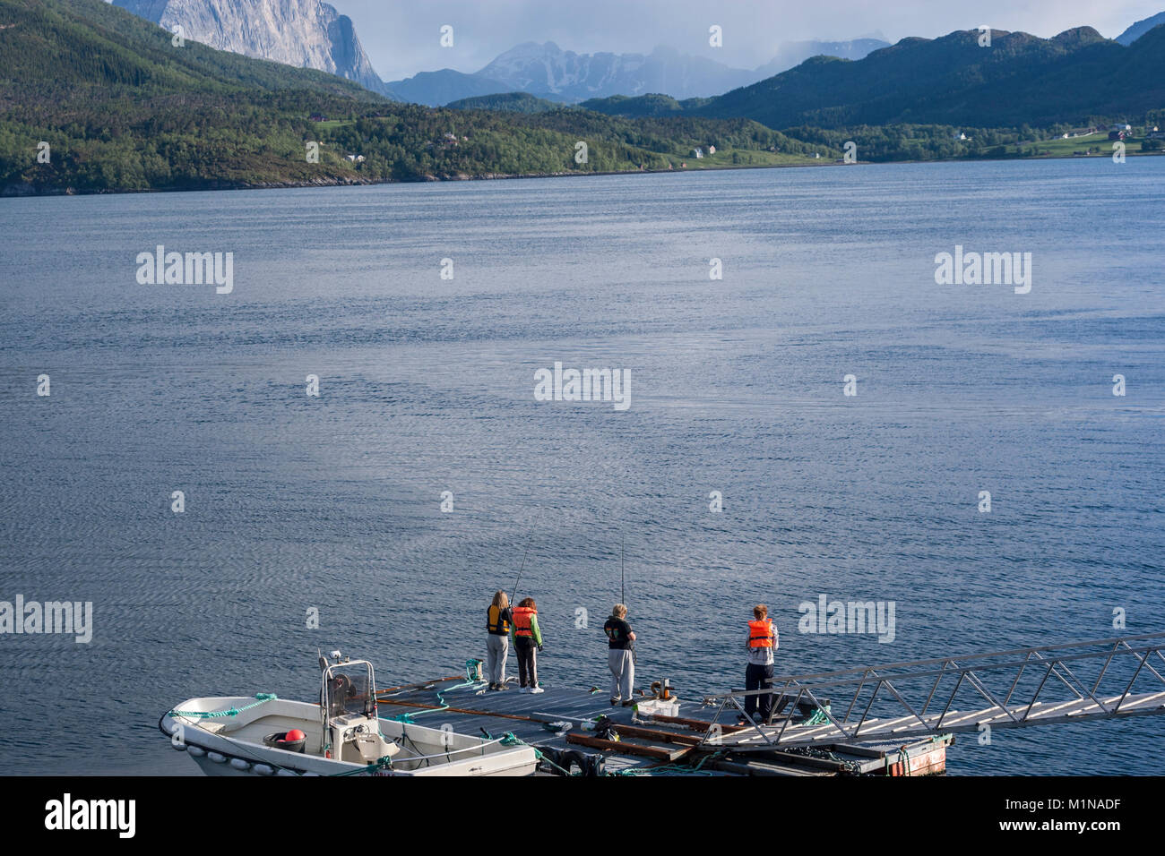 Four persons fishing along Norwegian County Road 17 from Bodo to Halsa ...