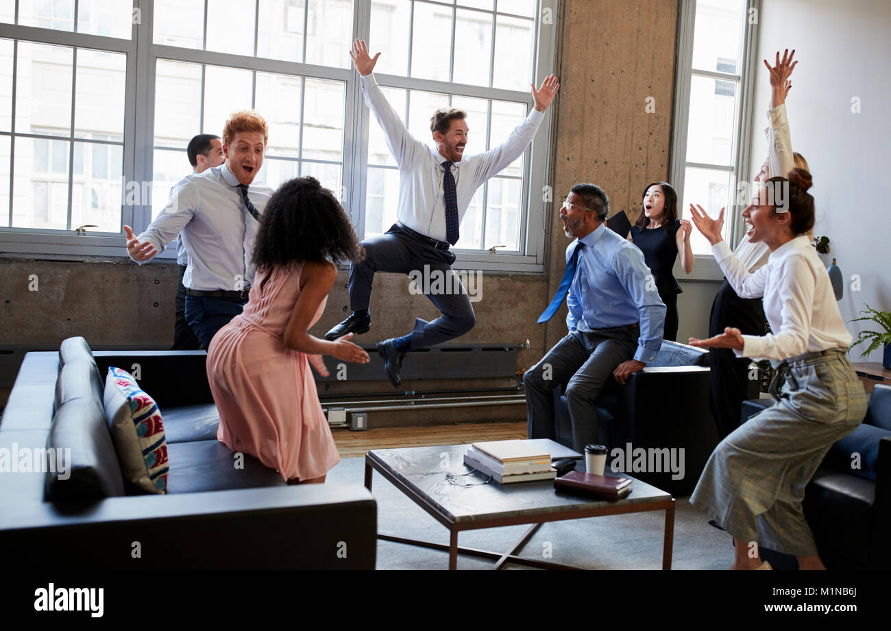 Business team jump for joy at hitting target in meeting Stock Photo - Alamy