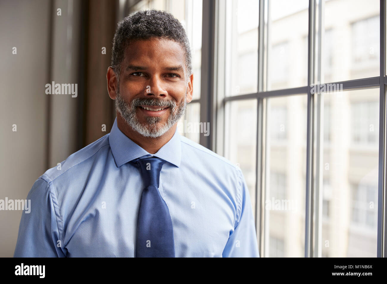 Middle aged black businessman smiling to camera Stock Photo - Alamy