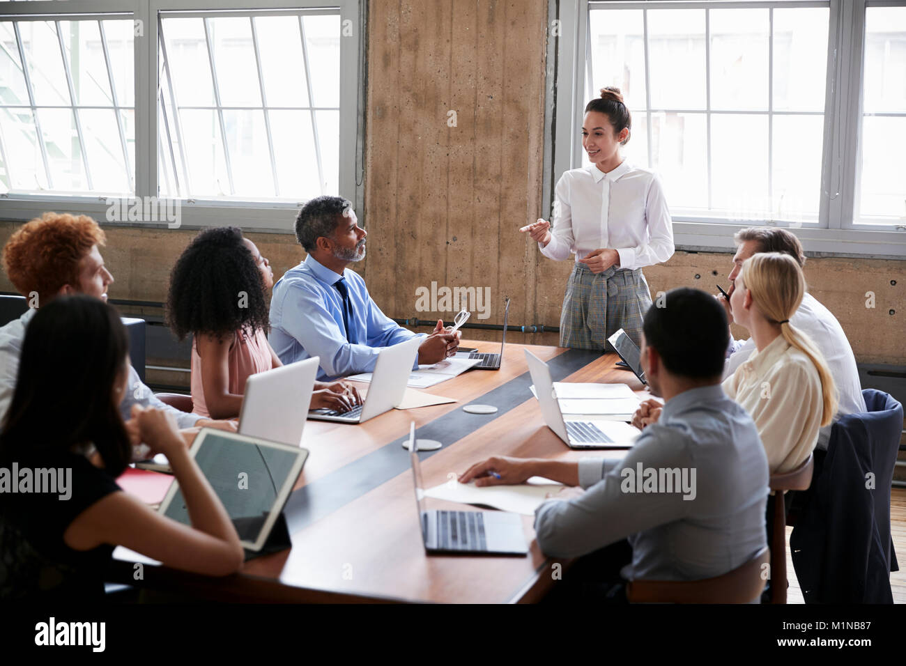 Businesswoman addressing colleagues table hi-res stock photography and ...