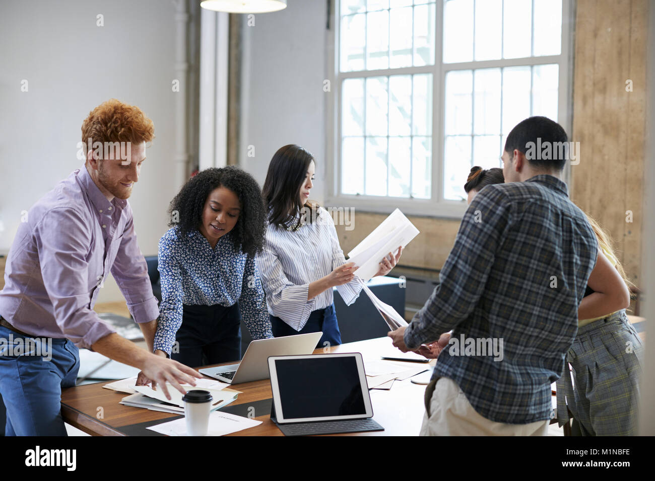 Young creatives discussing brainstorm ideas around a table Stock Photo ...