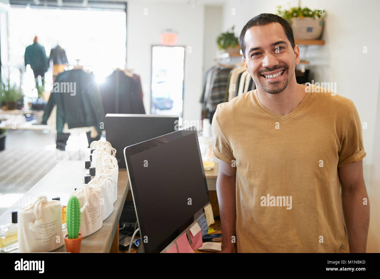 Male assistant smiling behind the counter in a clothes store Stock ...