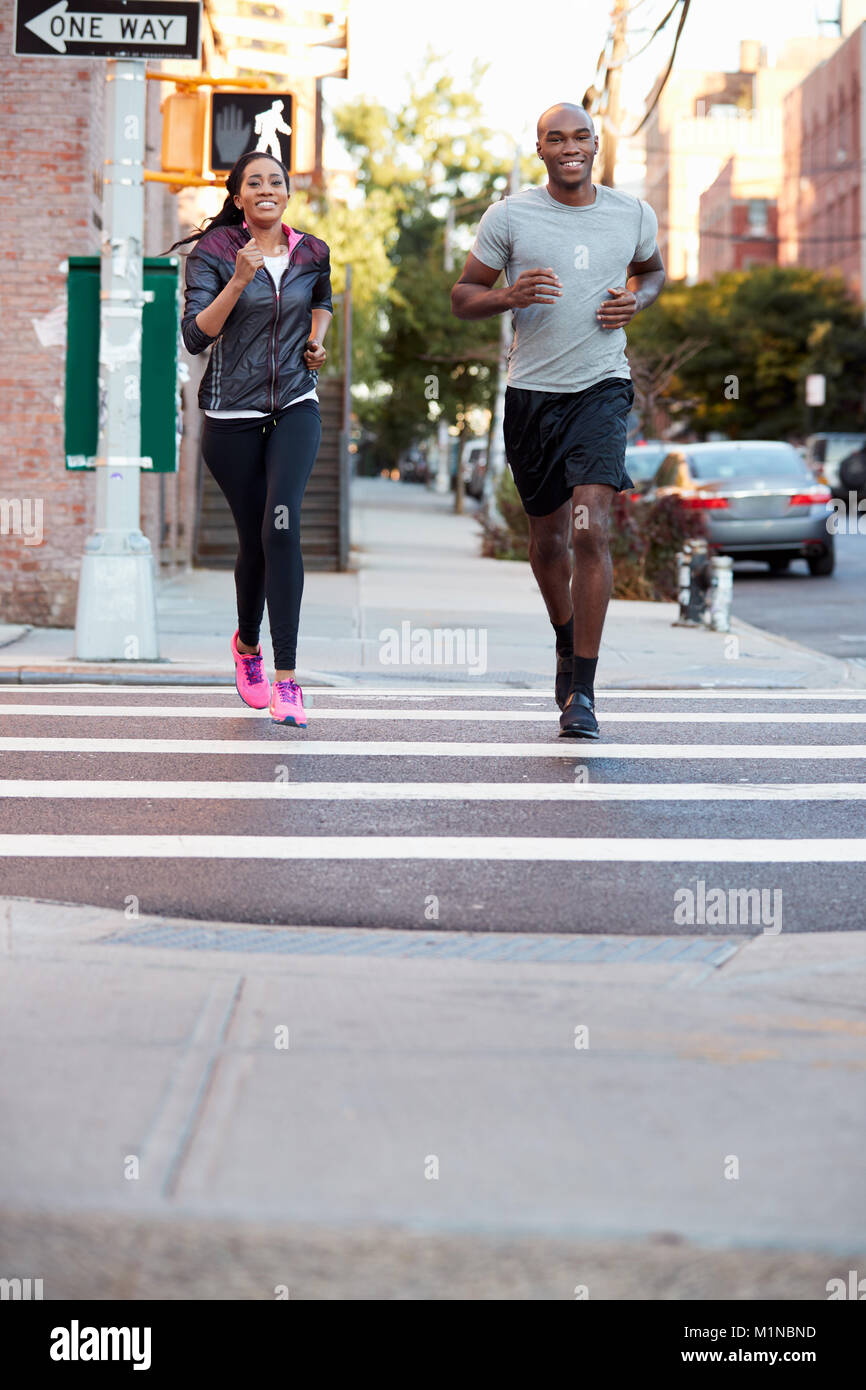 Young black couple jogging in Brooklyn, vertical Stock Photo - Alamy