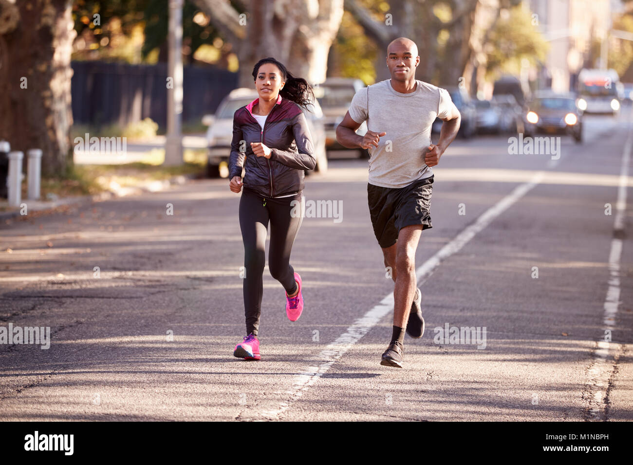 Young black couple jogging in a Brooklyn street Stock Photo - Alamy