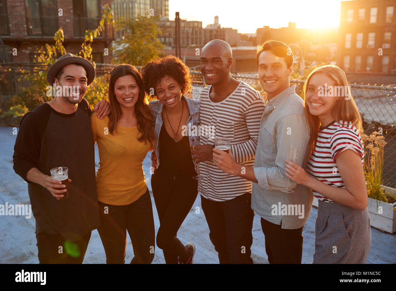 Friends at a rooftop party in Brooklyn smiling to camera Stock Photo ...