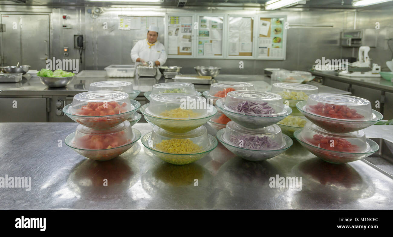 A commercial kitchen in a restaurant with cooks, food preparers and ...