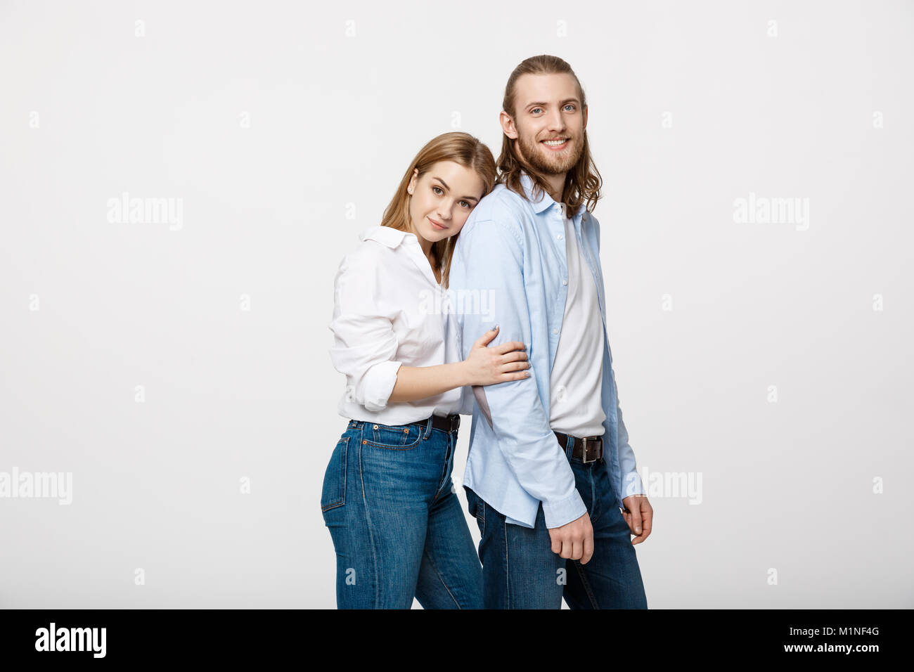 Portrait of cheerful young couple standing and hugging each other on ...