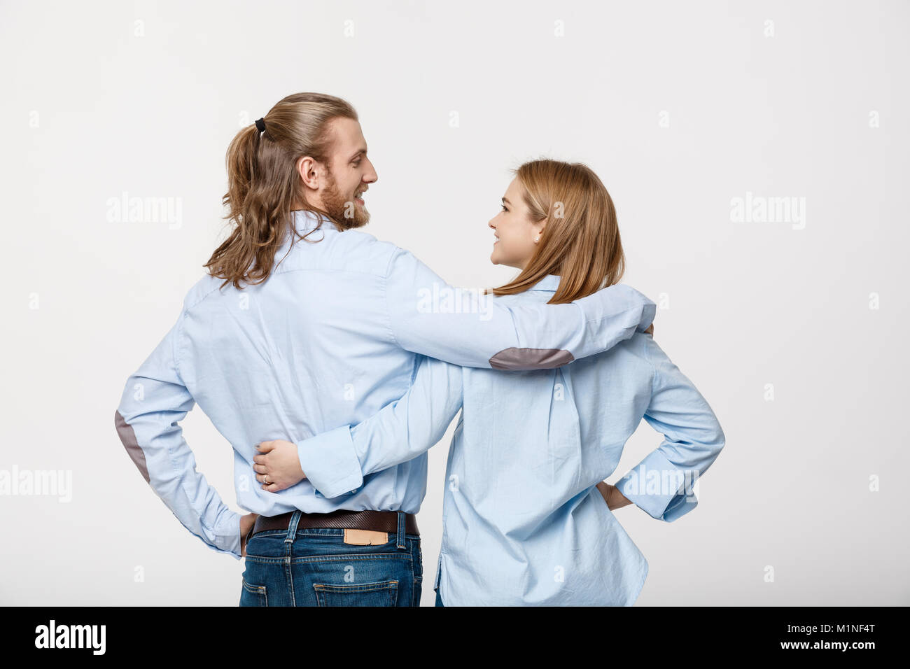 Portrait of cheerful young couple standing and hugging each other on ...