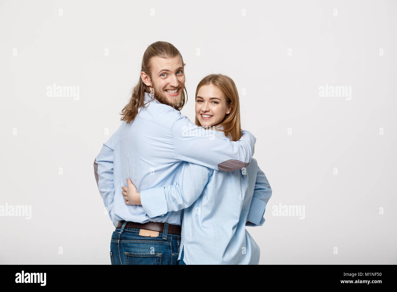 Portrait of cheerful young couple standing and hugging each other on ...