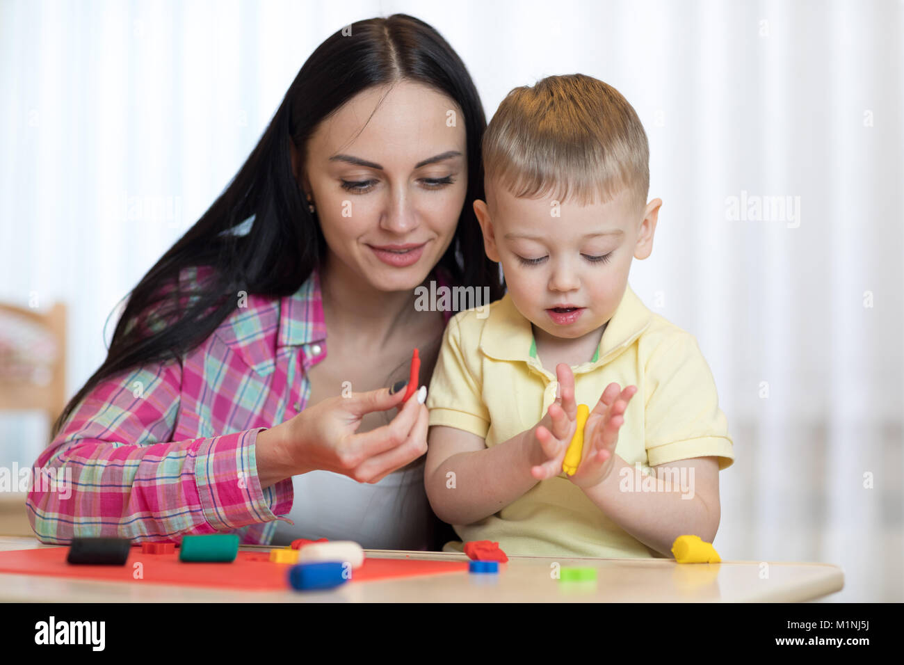 Woman teaches child son handcraft at home Stock Photo - Alamy