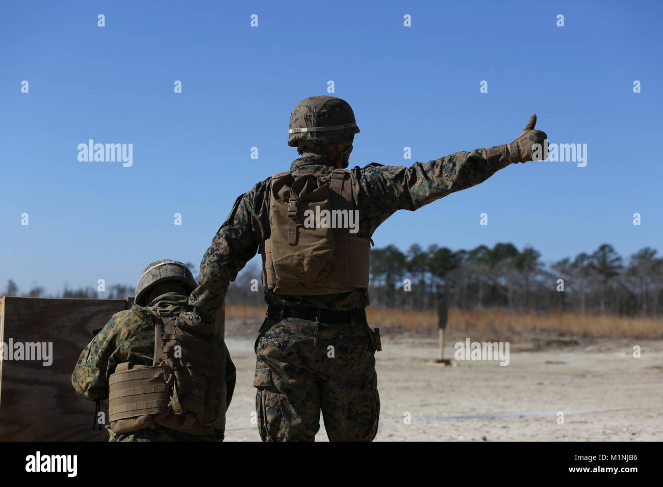 A range safety officer signals that his Marine is ready to fire during ...
