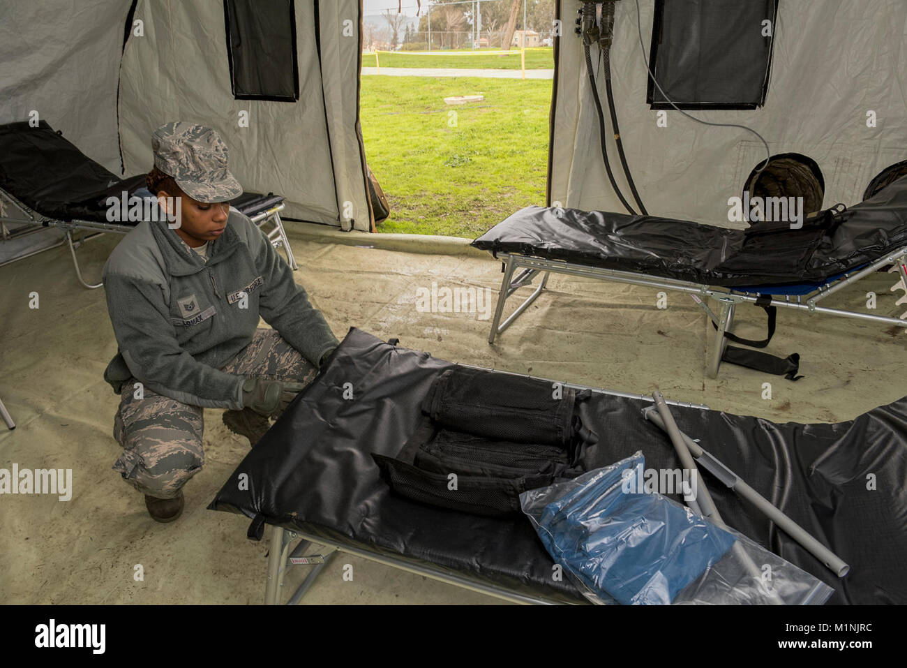 Tech. Sgt. Deloran Lomax, 60th Medical Group, sets up a cot in an En ...