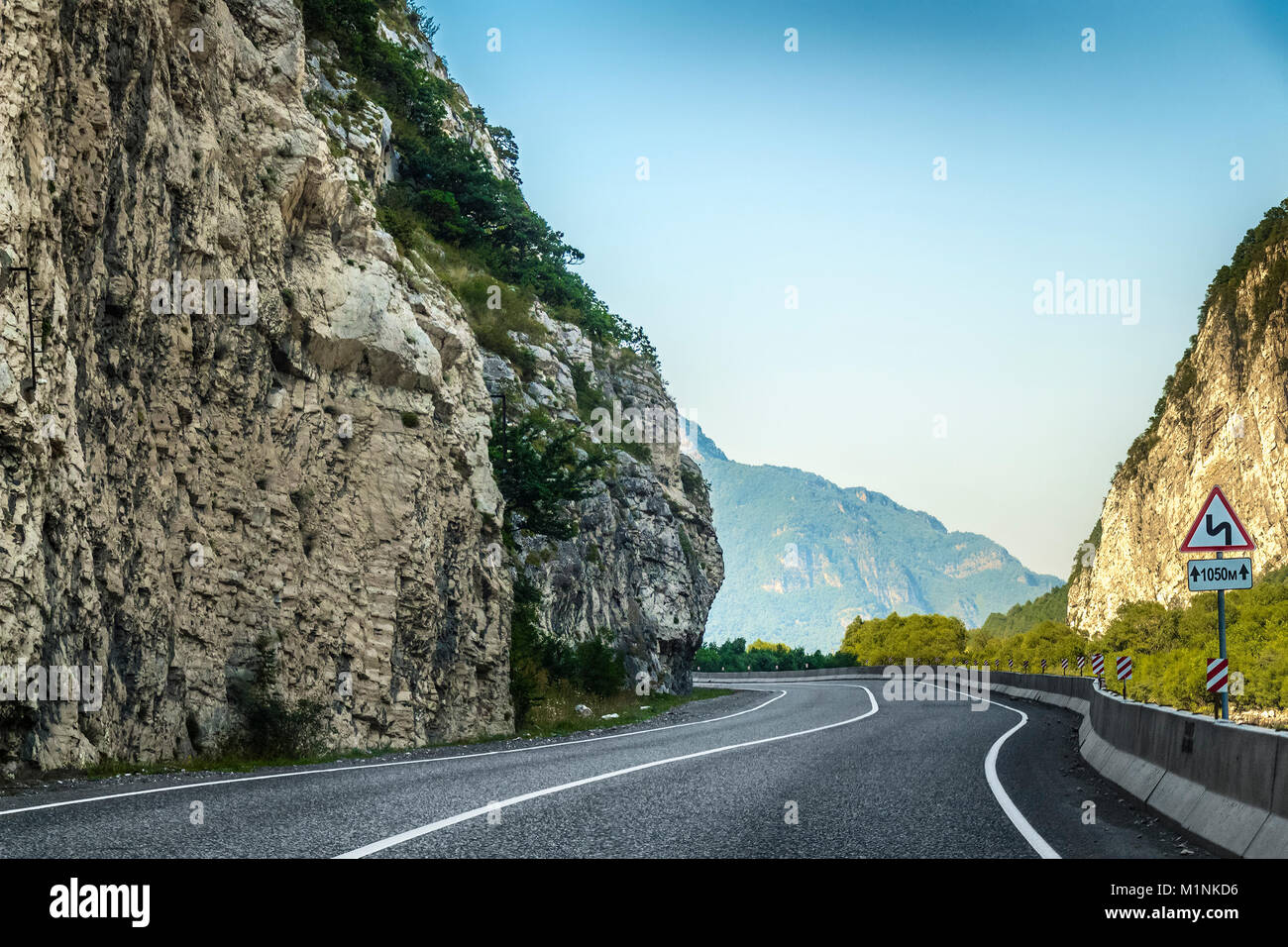 A sharp turn of a mountain road with a gray asphalt pavement Stock ...
