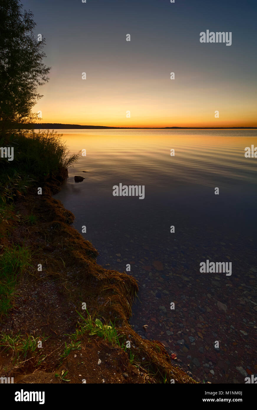 Beautiful evening view of a lake on a sunset background Stock Photo - Alamy
