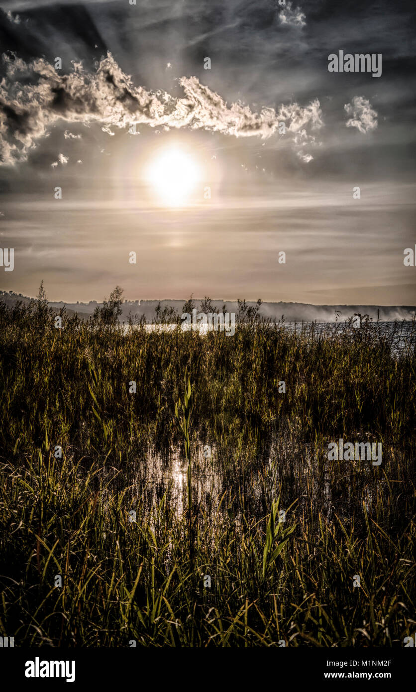 A dramatic sunset over a dark lake Stock Photo - Alamy