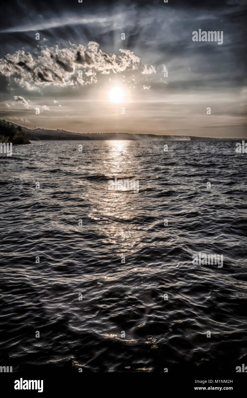 A dramatic sunset over a dark lake Stock Photo - Alamy