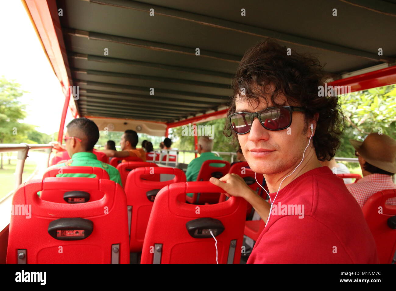 Young man sitting on a double decker red bus in Panama City douring a ...