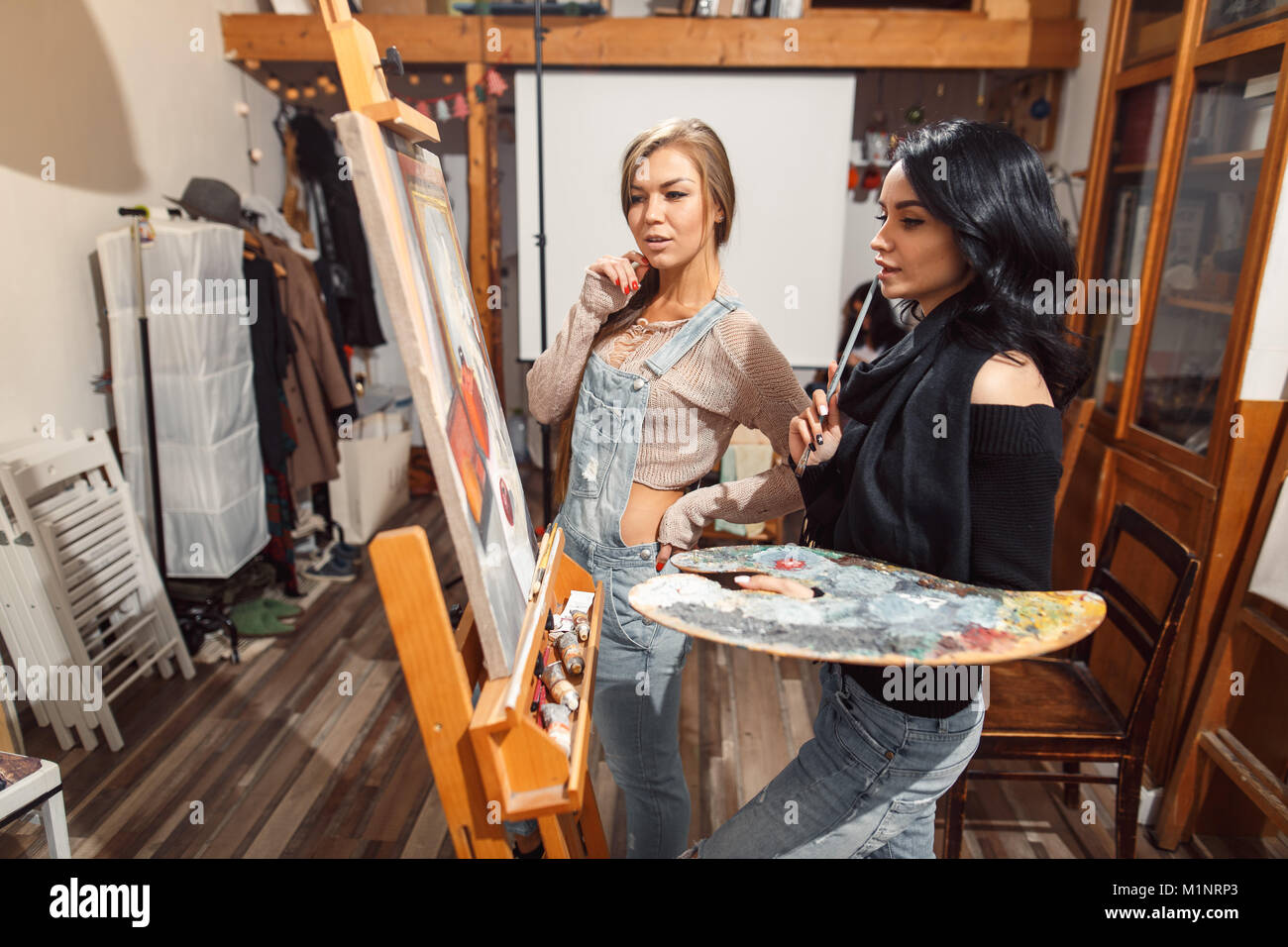 two girls in an artist studio. paints model Stock Photo - Alamy