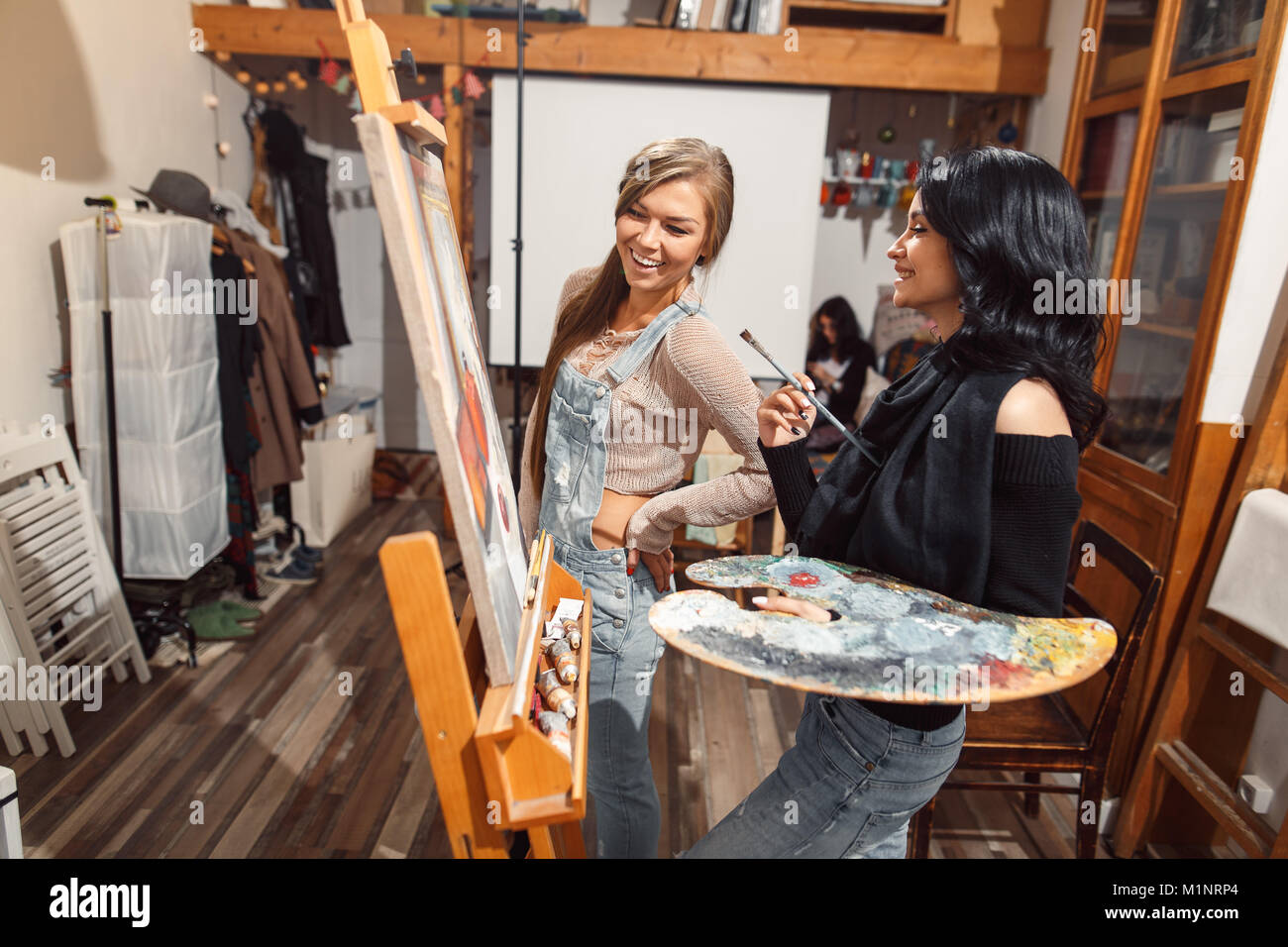 two girls in an artist studio. paints model Stock Photo - Alamy